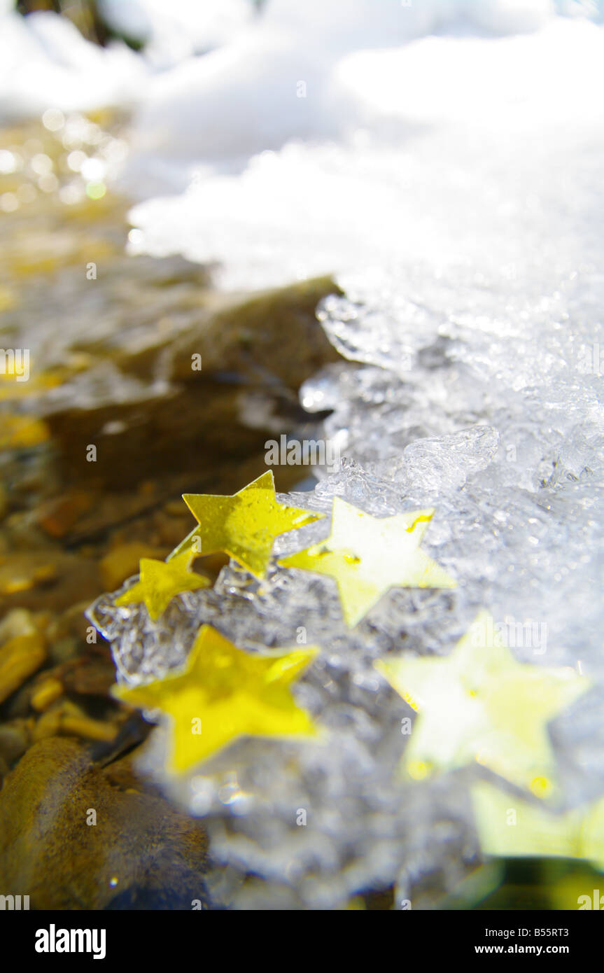 golden snow stars on a real snowy icy surface Stock Photo - Alamy