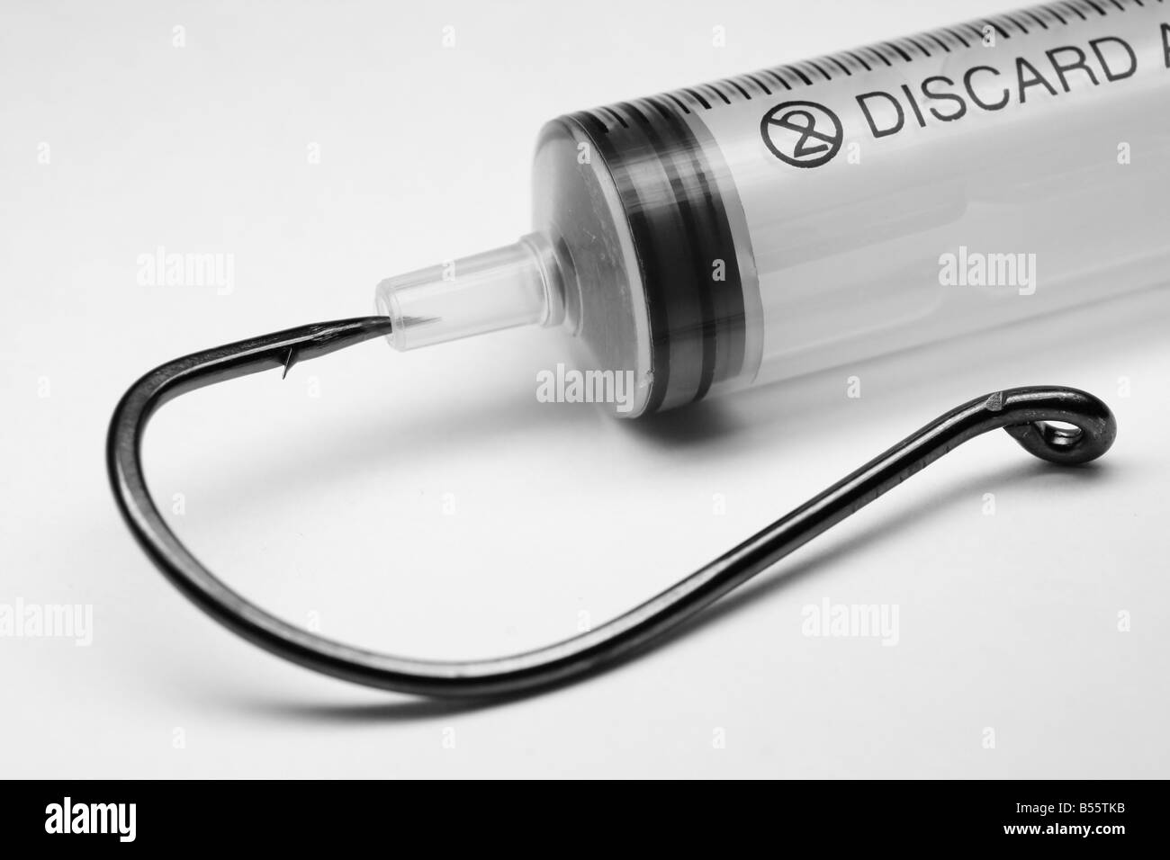 Close-up of fish hook and syringe on white background Stock Photo - Alamy