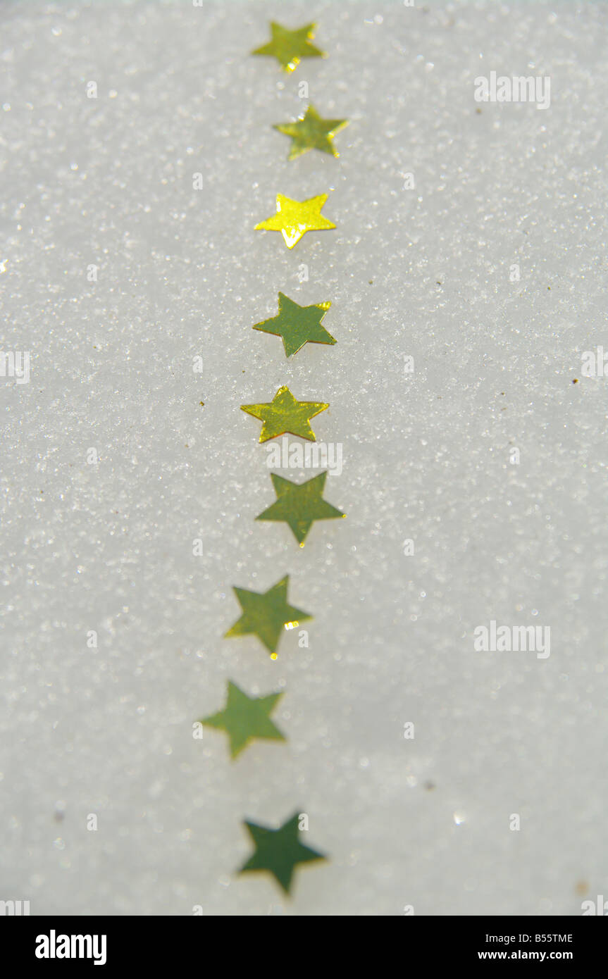 golden snow stars on a real snowy icy surface Stock Photo - Alamy