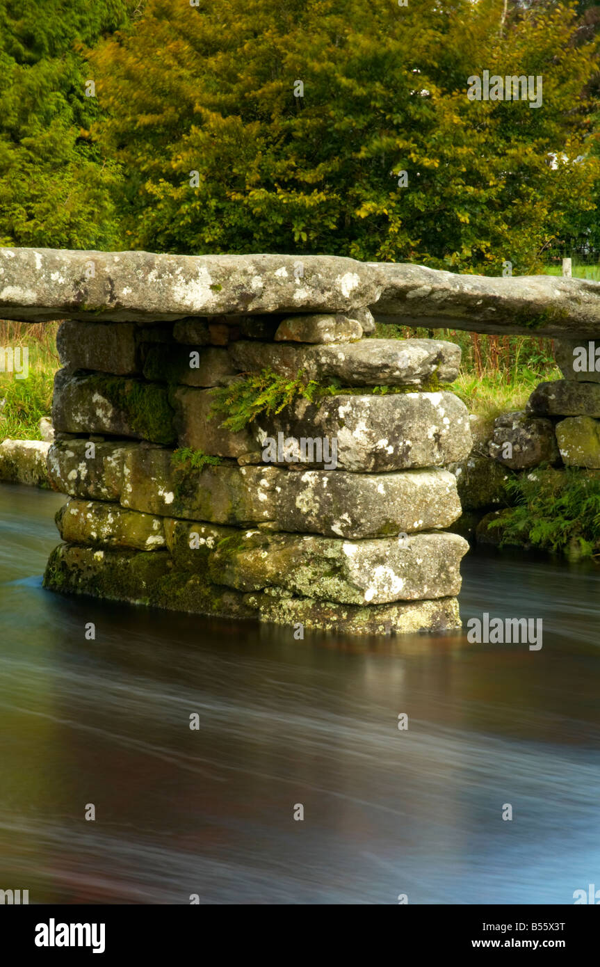 The River Dart flowing under a stone clapper bridge on Dartmoor Devon ...