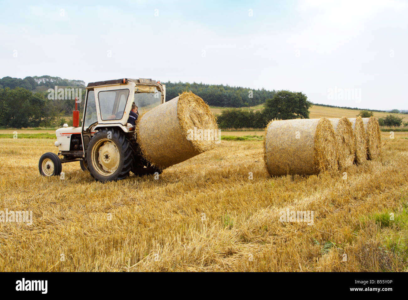 tractor gathering hay bales Stock Photo - Alamy
