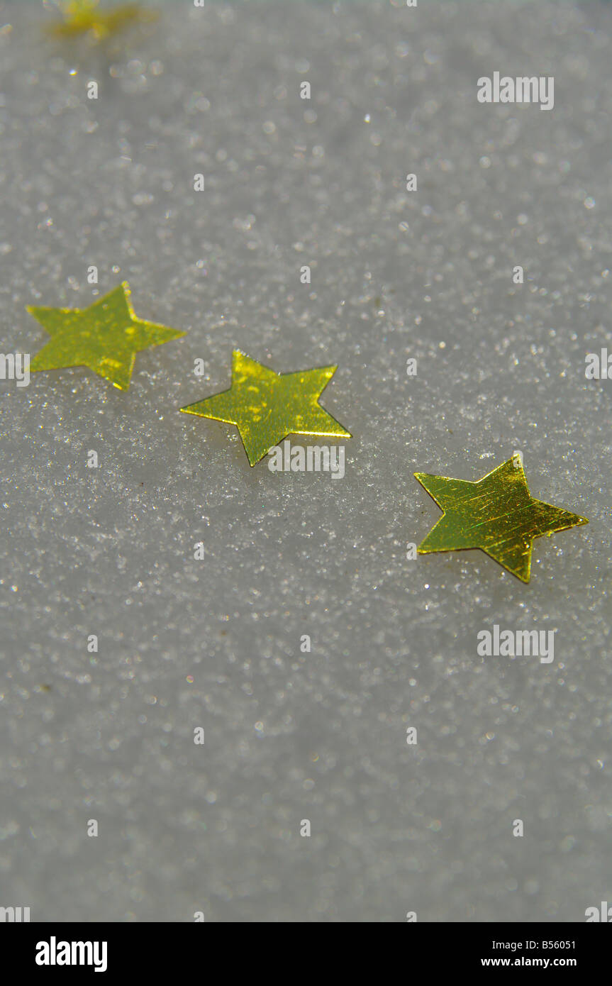 golden snow stars on a real snowy icy surface Stock Photo - Alamy