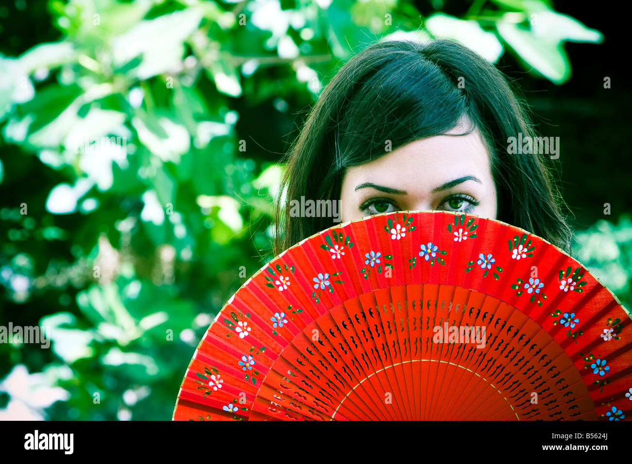 Spanish woman behind traditional fan Stock Photo - Alamy