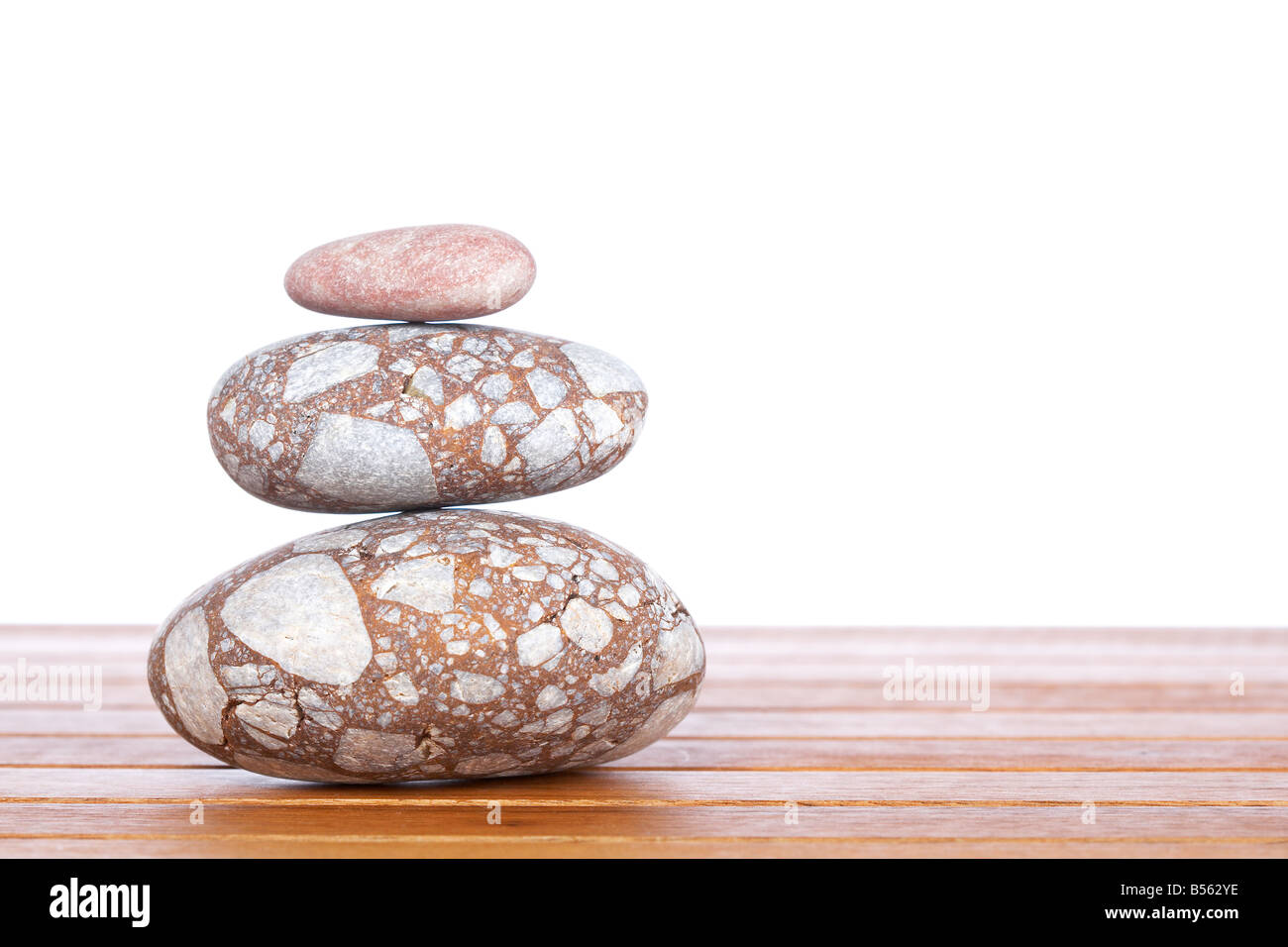 Stack of balanced stones with shadow on wooden background Stock Photo ...