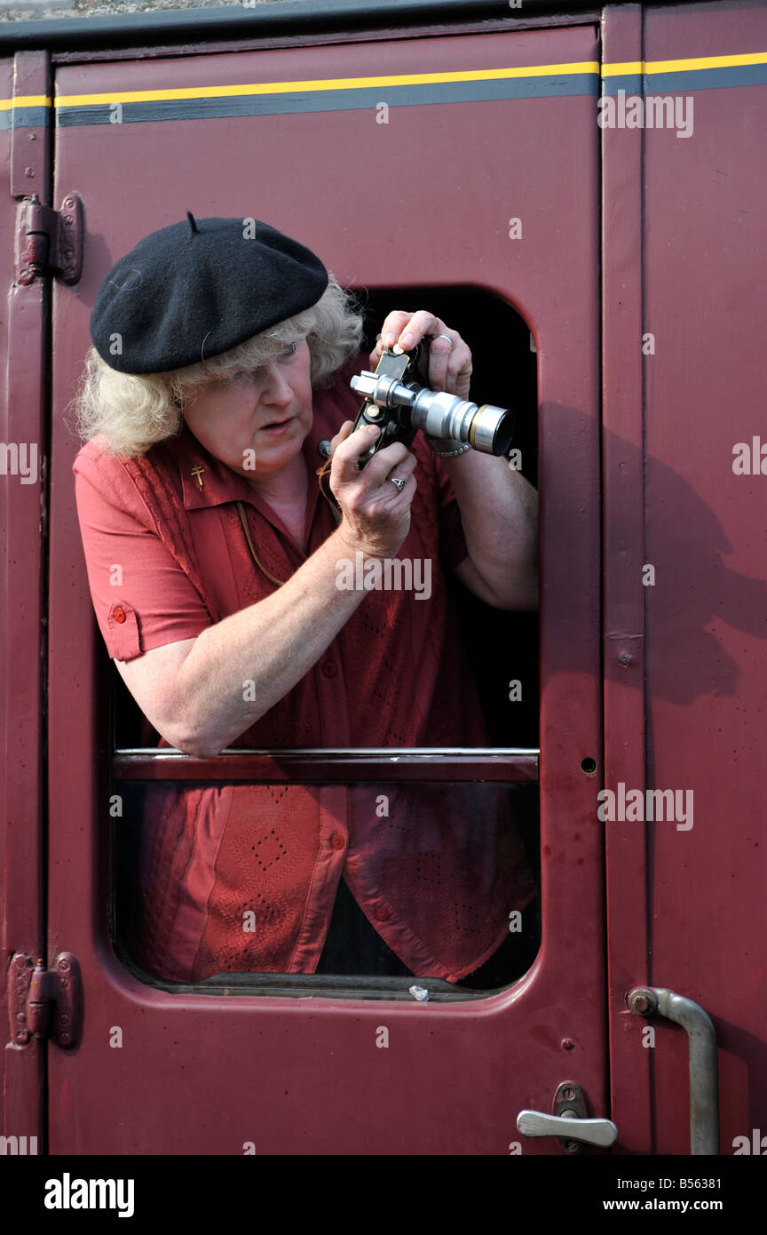 woman dressed in 1940's clothing leans out of train window with vintage ...