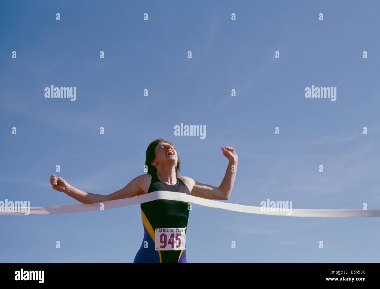 Women victoriously crossing the finish line of track race Stock Photo ...