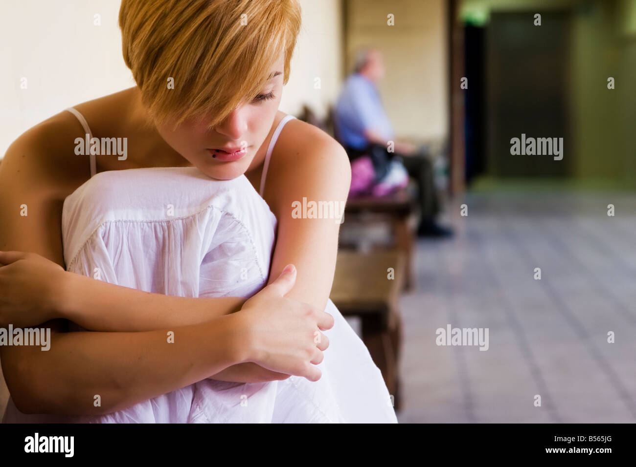 Sad blond woman waiting near door Stock Photo - Alamy