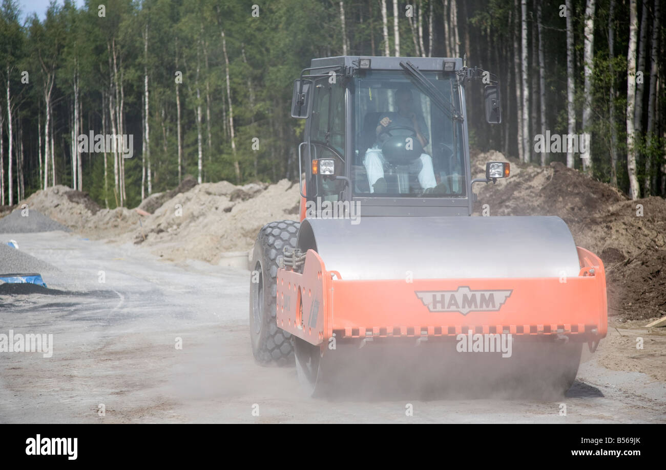 Hamm road roller compactor at road building site compacting the roadbed ...