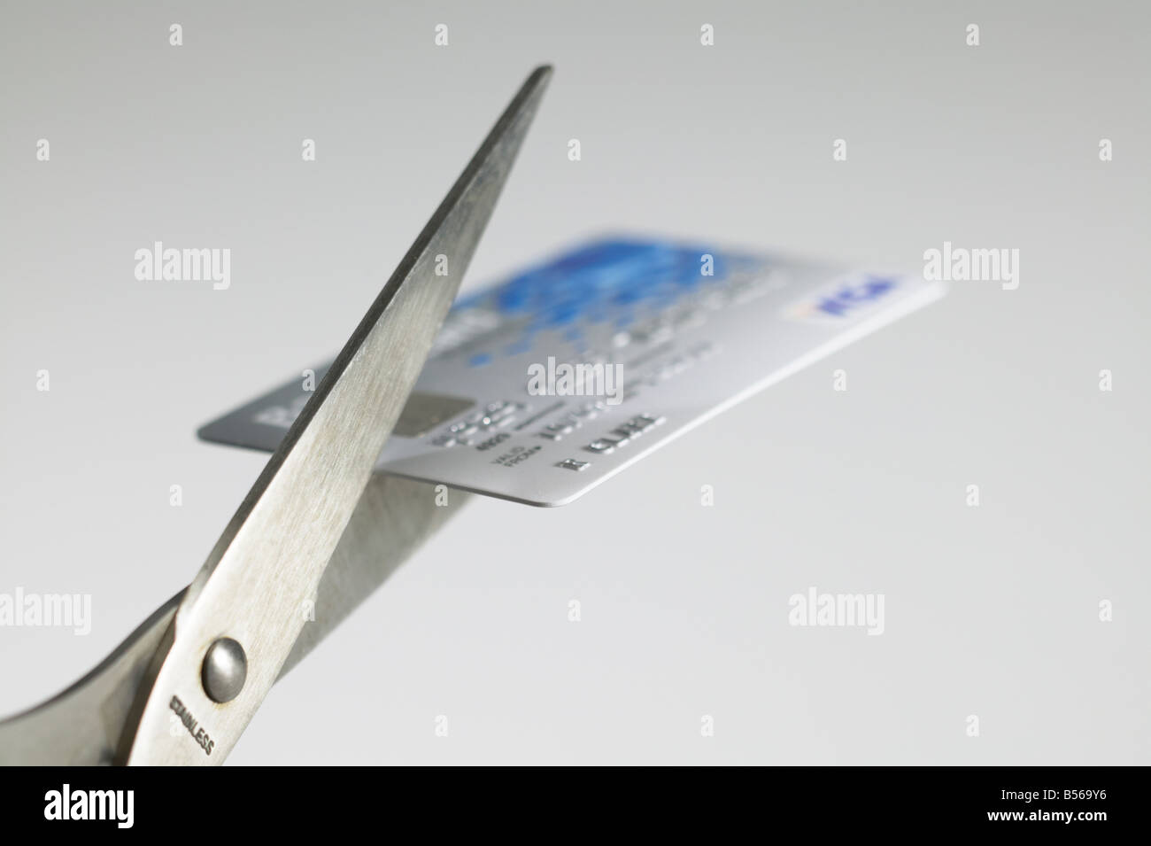 Cutting credit card with pair of scissors Stock Photo - Alamy