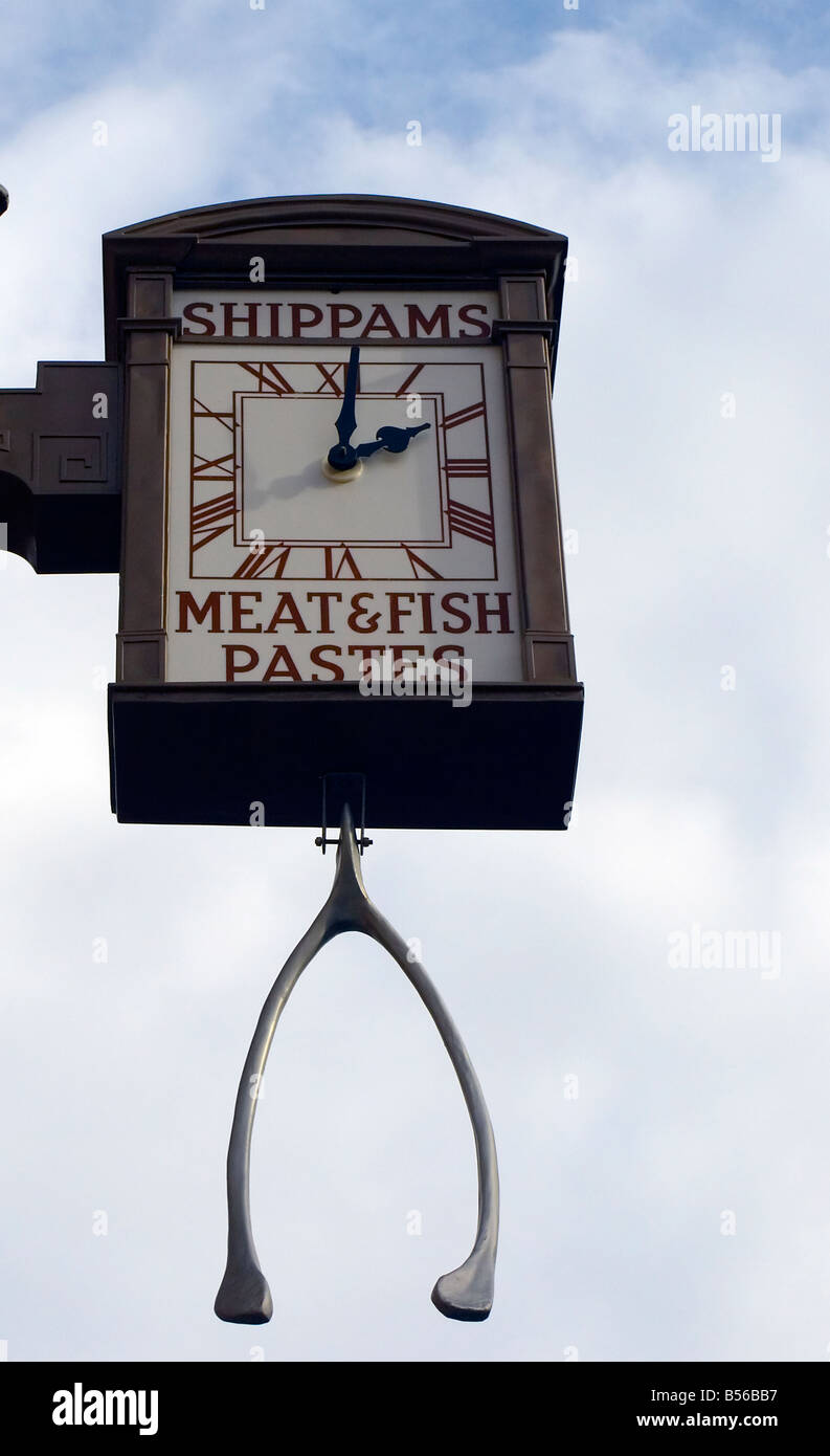 Overhanging renovated street sign with a clock reading Shippams Meat ...