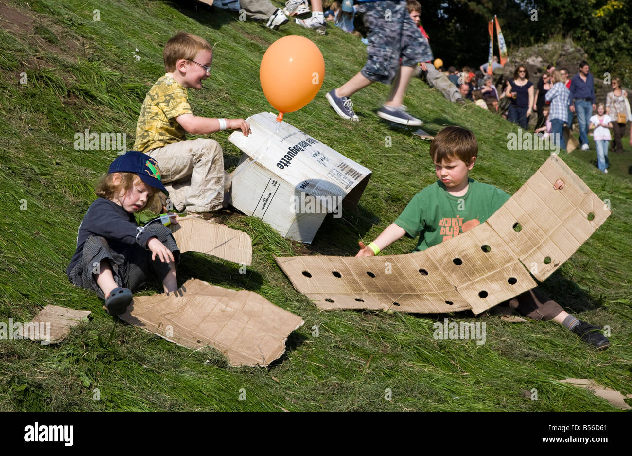 Children sliding on cardboard playing on slope Wales UK Stock Photo - Alamy