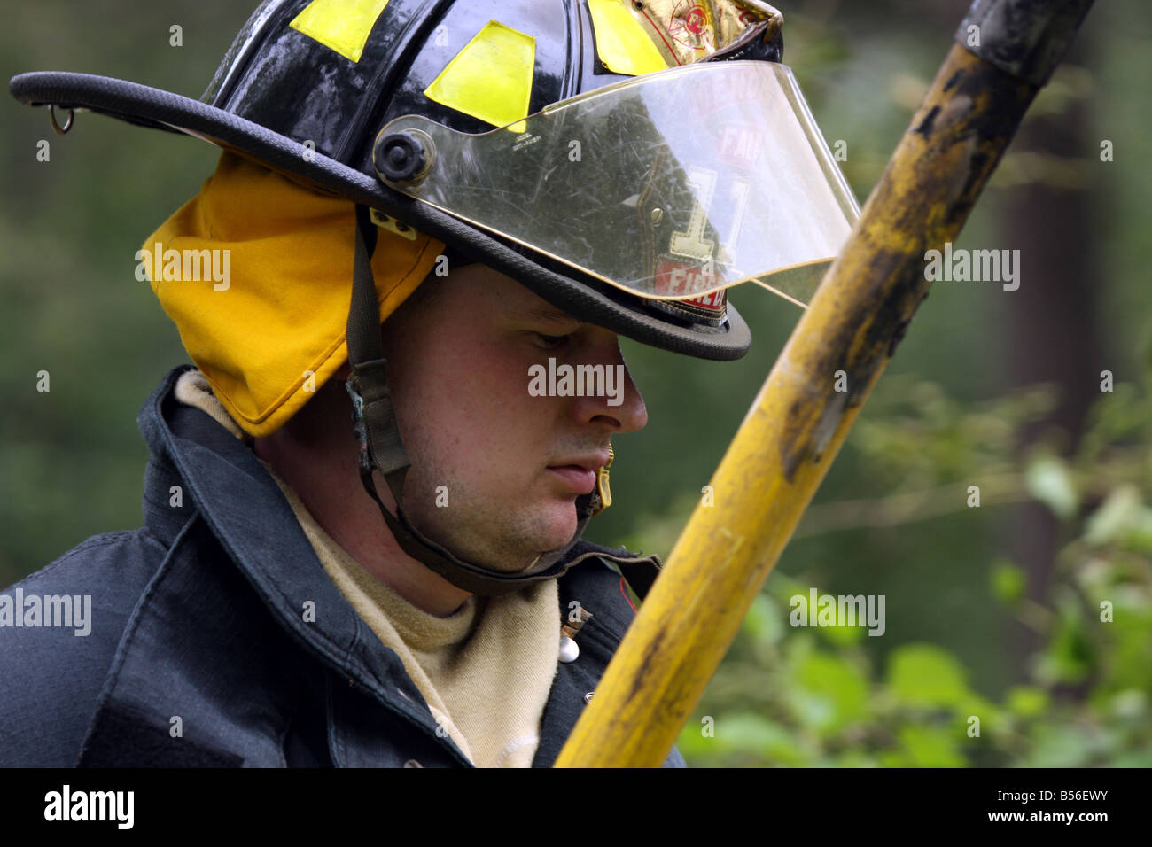 A firefighter holding a pole pick at a fire scene Stock Photo - Alamy