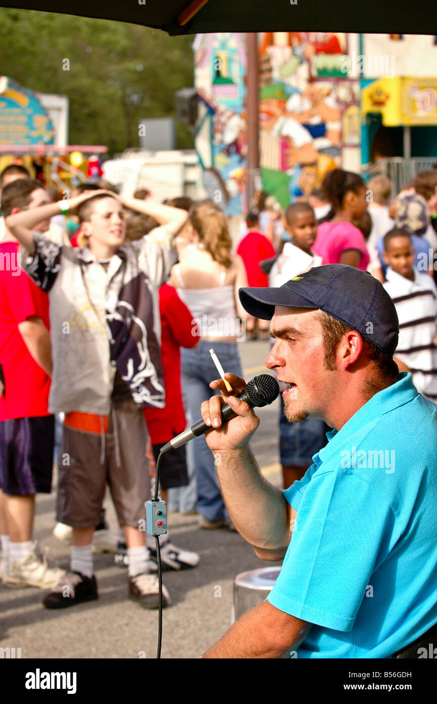 An amusement park employee gathers a crowd with a microphone Stock ...