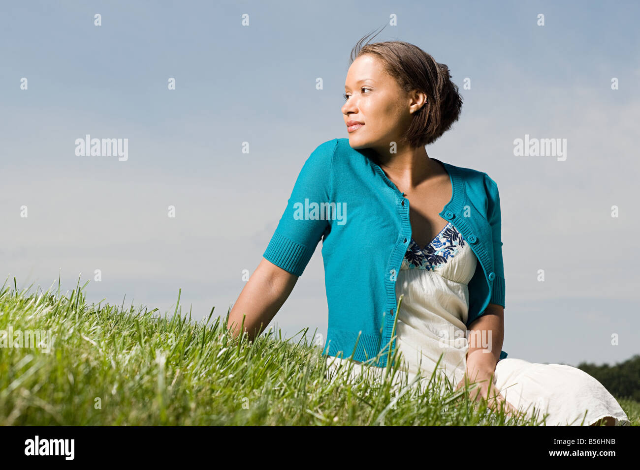 Woman sitting on grass Stock Photo - Alamy