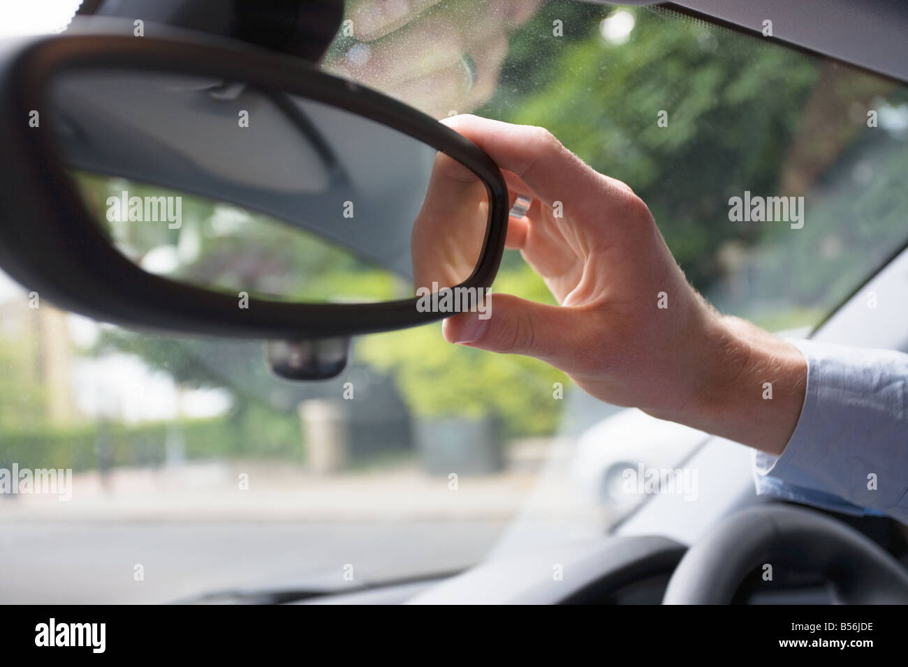 A man adjusting a rearview mirror Stock Photo - Alamy