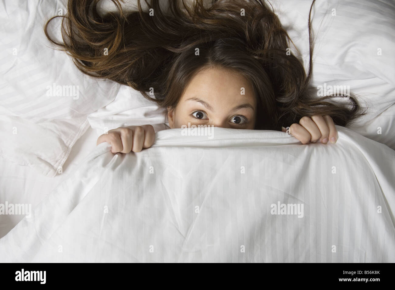 Woman hiding under duvet hi-res stock photography and images - Alamy