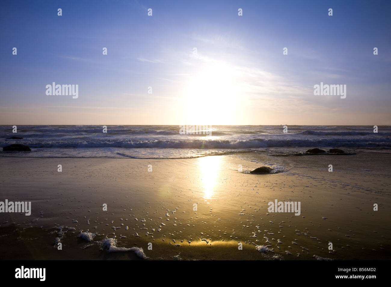 Sunset on a beach Stock Photo - Alamy