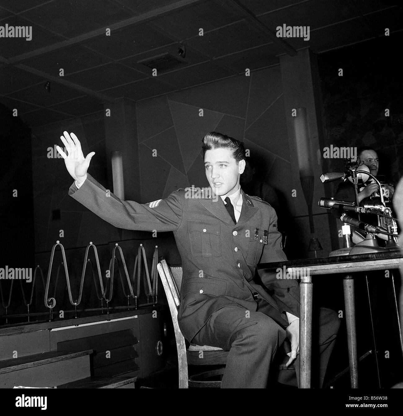 Elvis Presley wearing army uniform waves at press conference in Germany ...