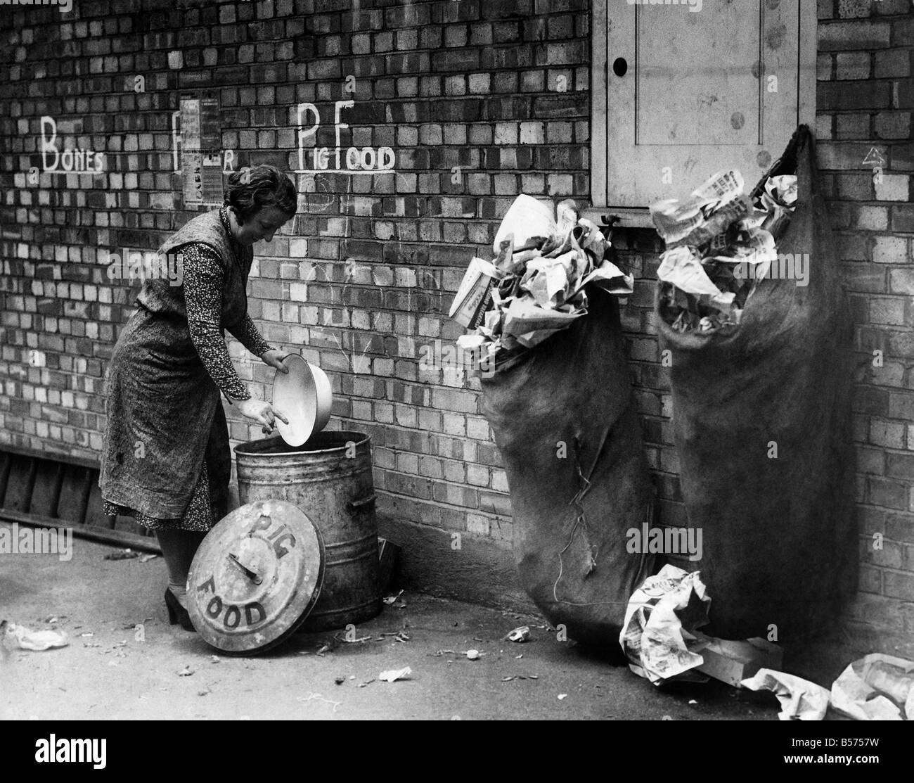 World War II: War on waste on the home front. A woman scrapes the ...