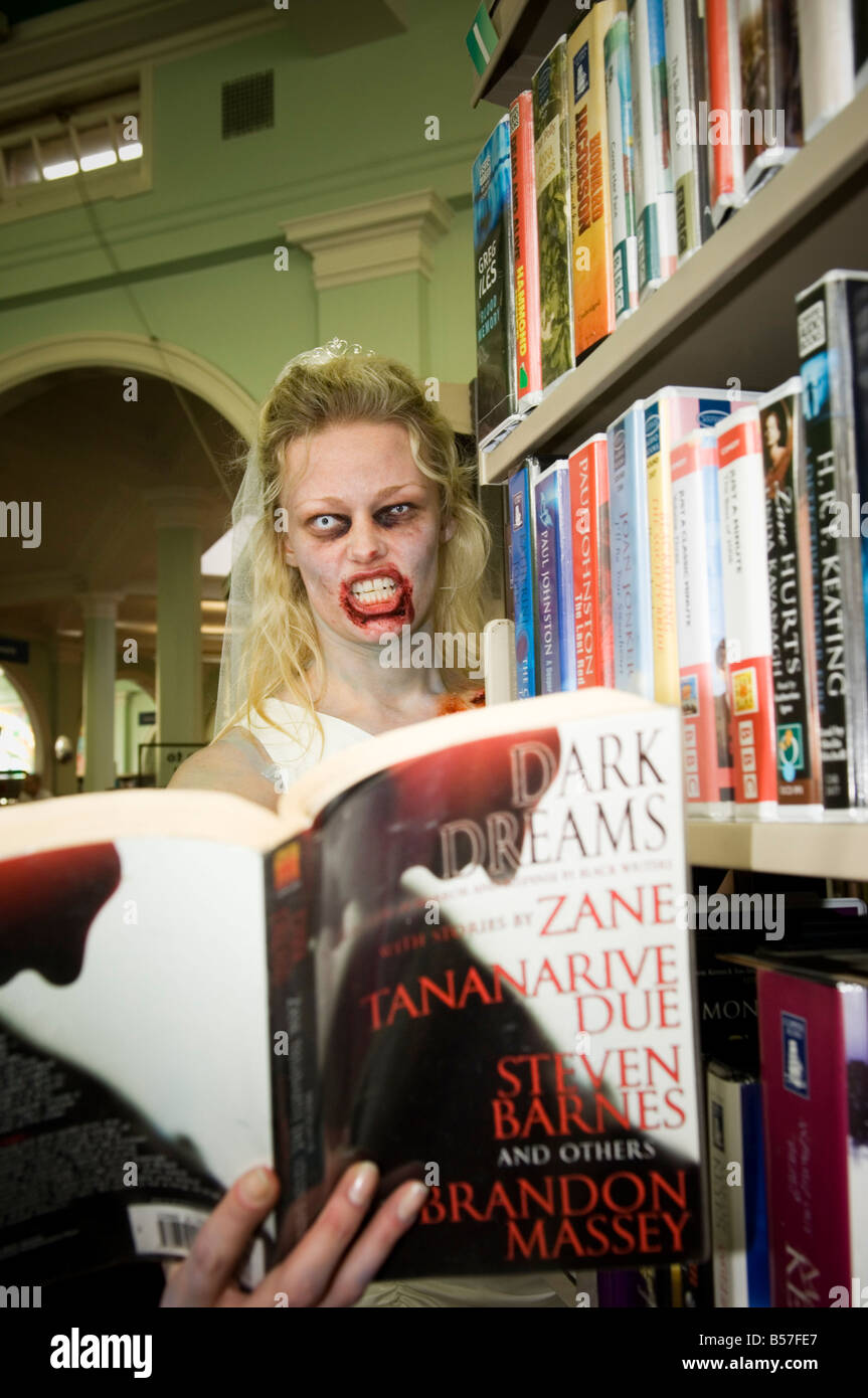 Zombie reads up on dead things in the local library Stock Photo - Alamy