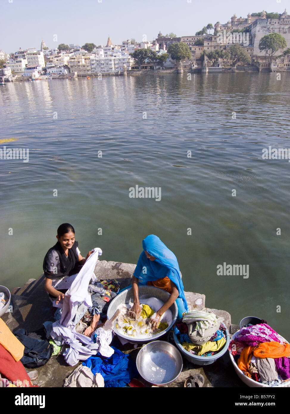local women washing laundry and chatting life style in the lake Pichola ...