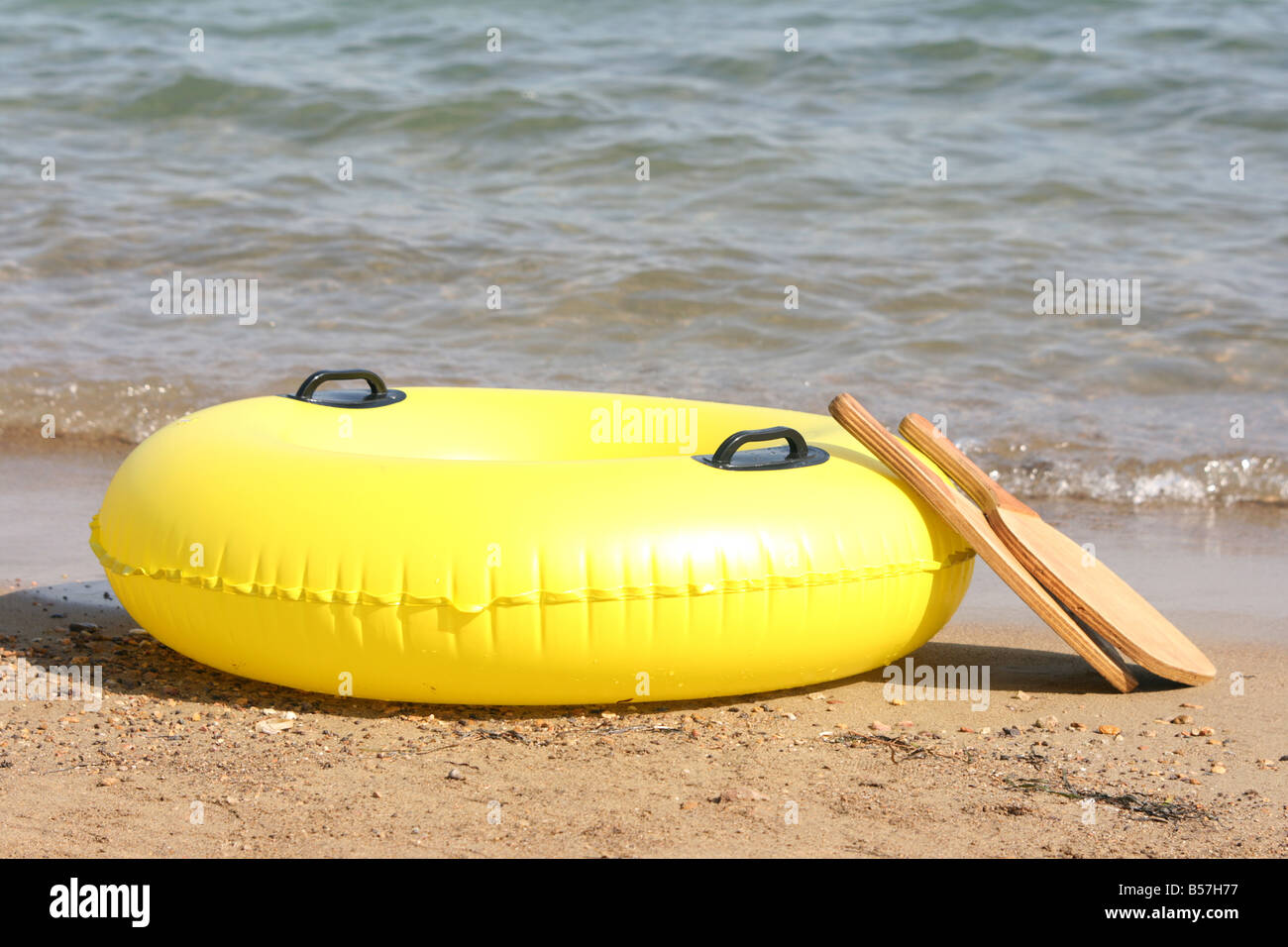 yellow inflatable by the sea and wooden beach tennis rackets Stock ...