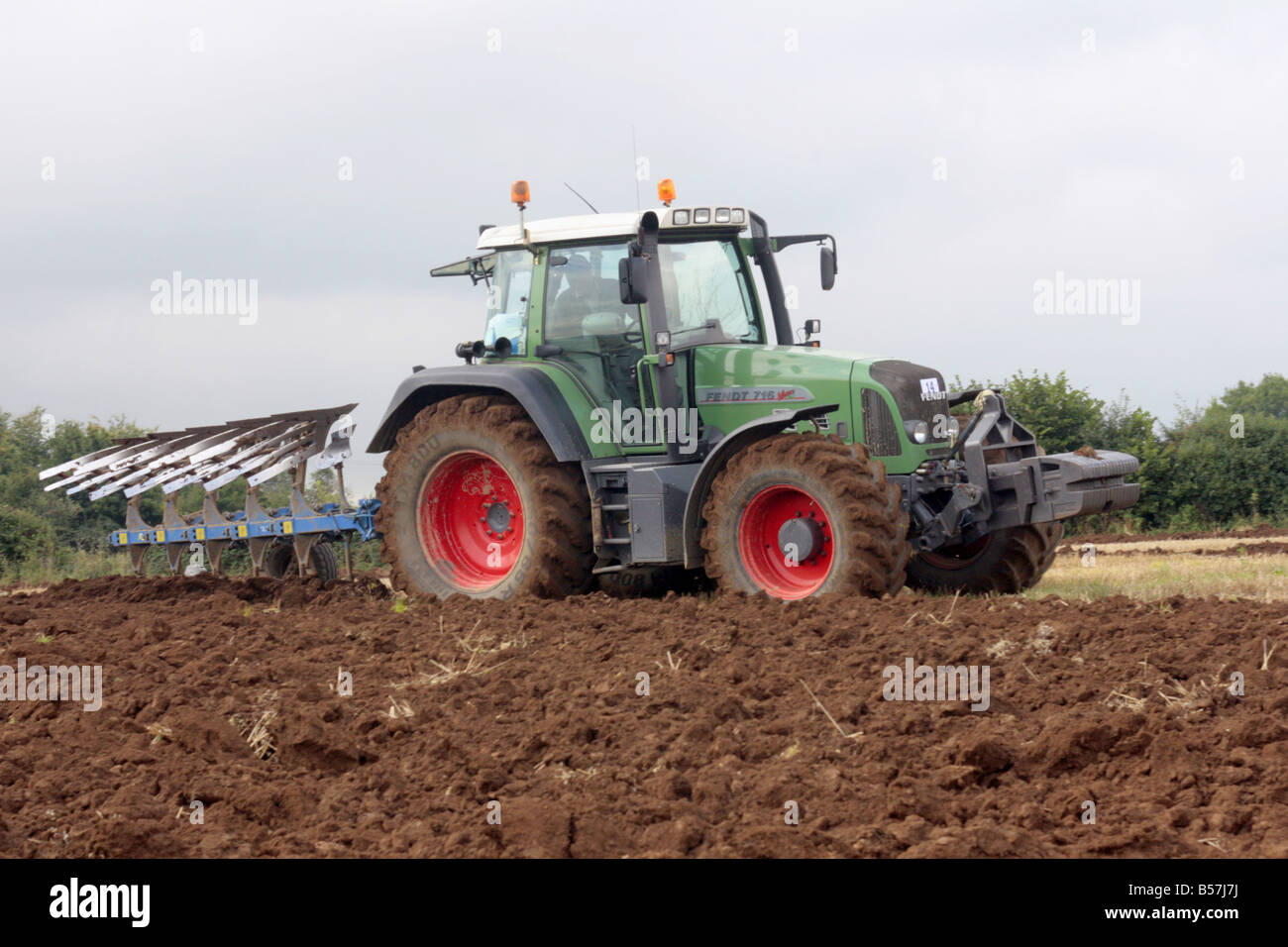 Farmers have a hard days work ploughing their tractor fields Stock ...