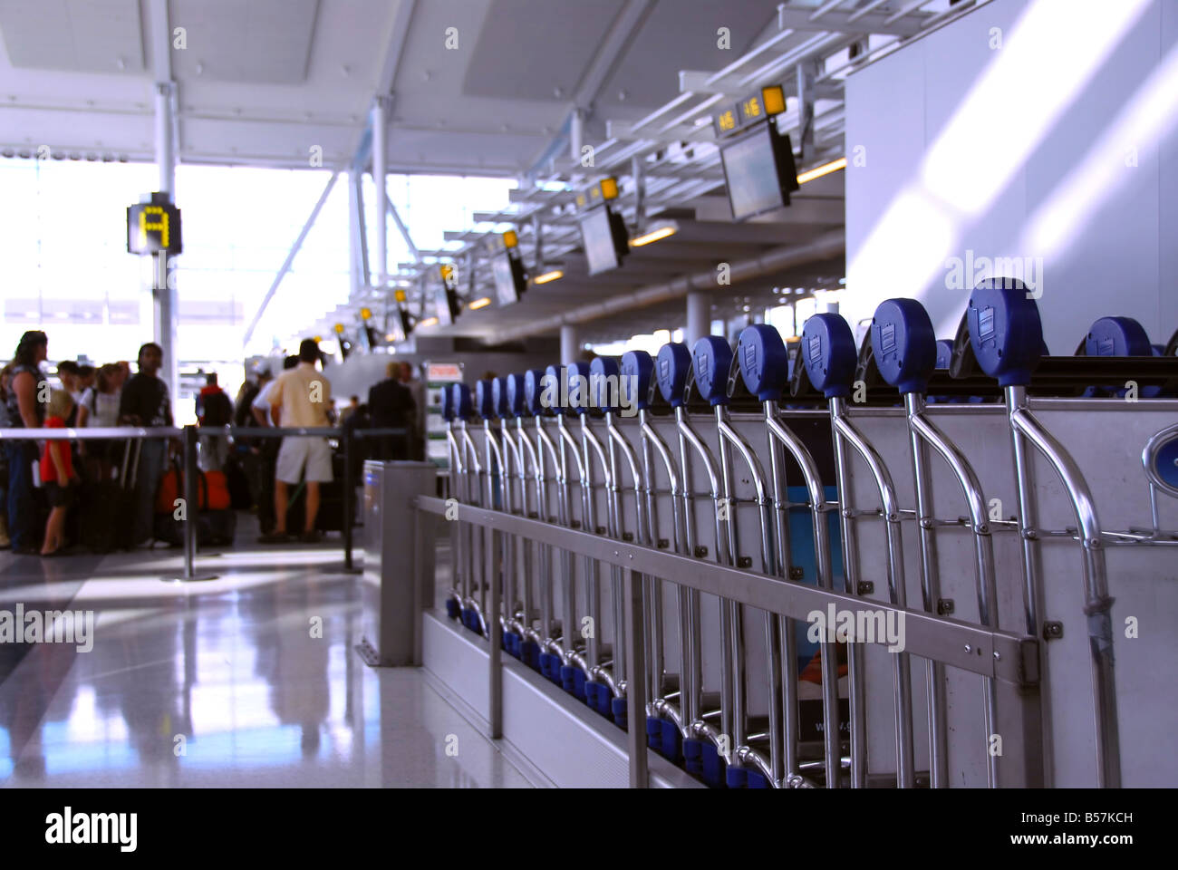 Passengers lining up at the check in counter at the modern ...