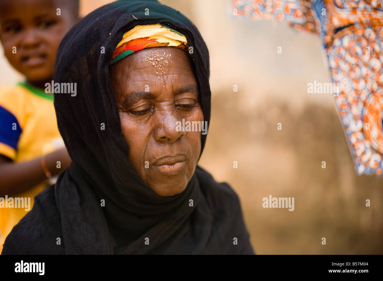 Elderly Mossi woman in Ouagadougou, Burkina Faso, her grandson in the ...