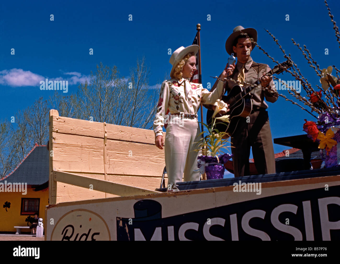 Country and western singer singing and playing guitar on a flatbed ...