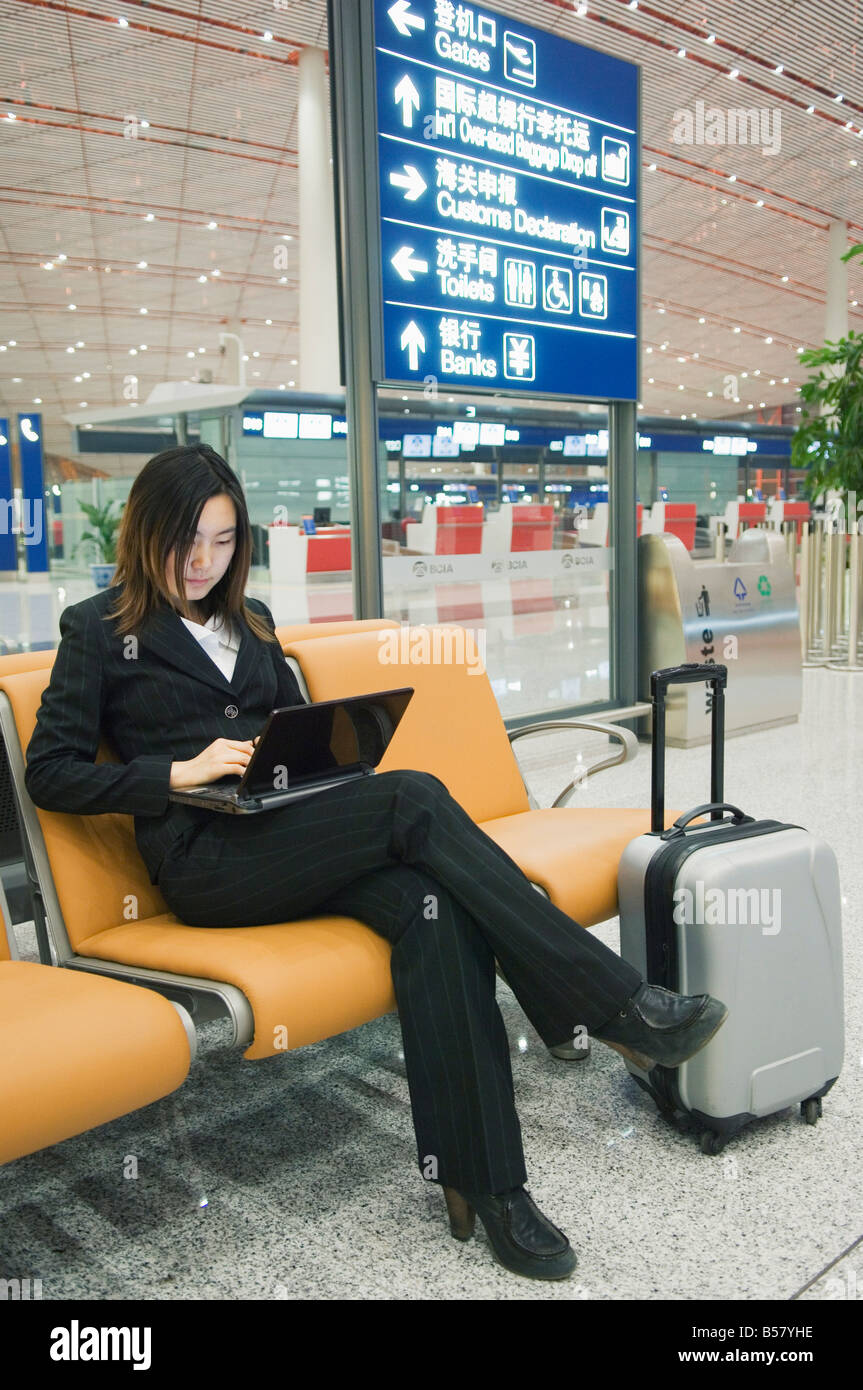 A Chinese business woman using a laptop computer at Beijing Capital ...