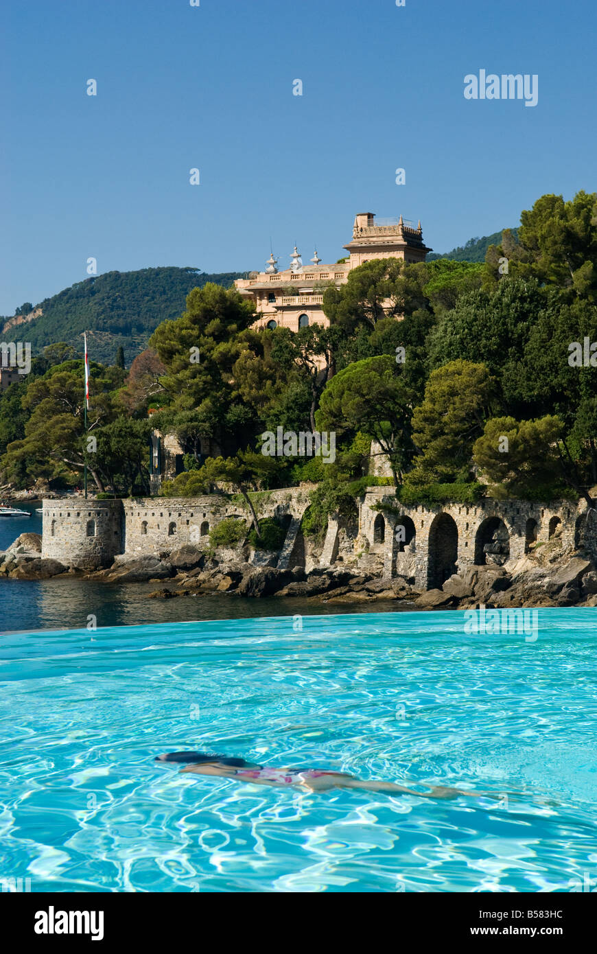 Infinity pool with underwater swimmer showing the Italian Riviera in ...