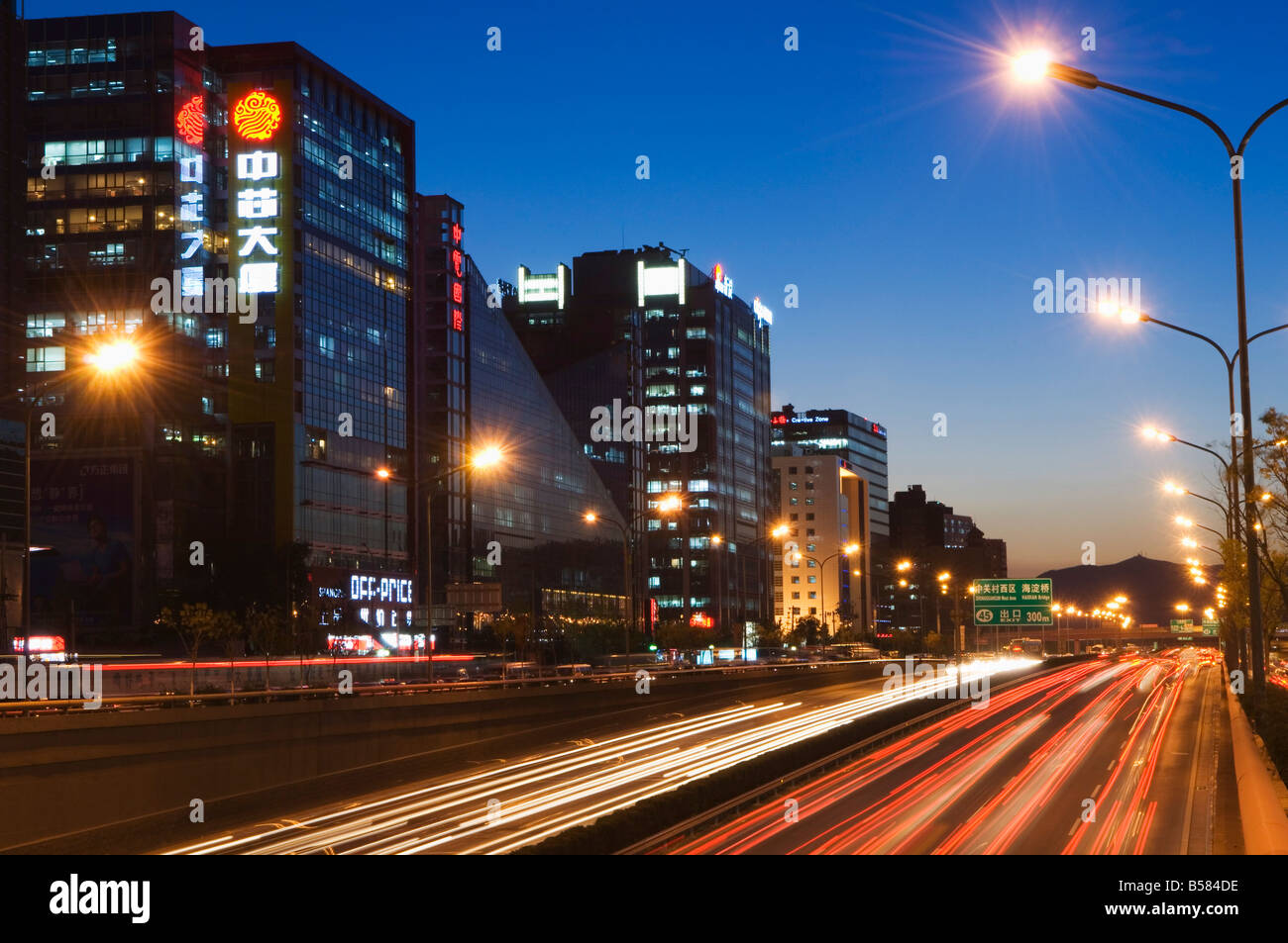 Car light trails and modern architecture on a city ring road, Beijing ...