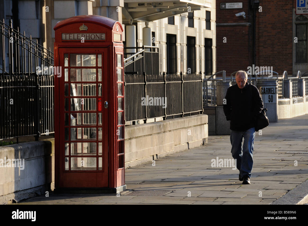 A man walking past a telephone box, London, UK Stock Photo - Alamy