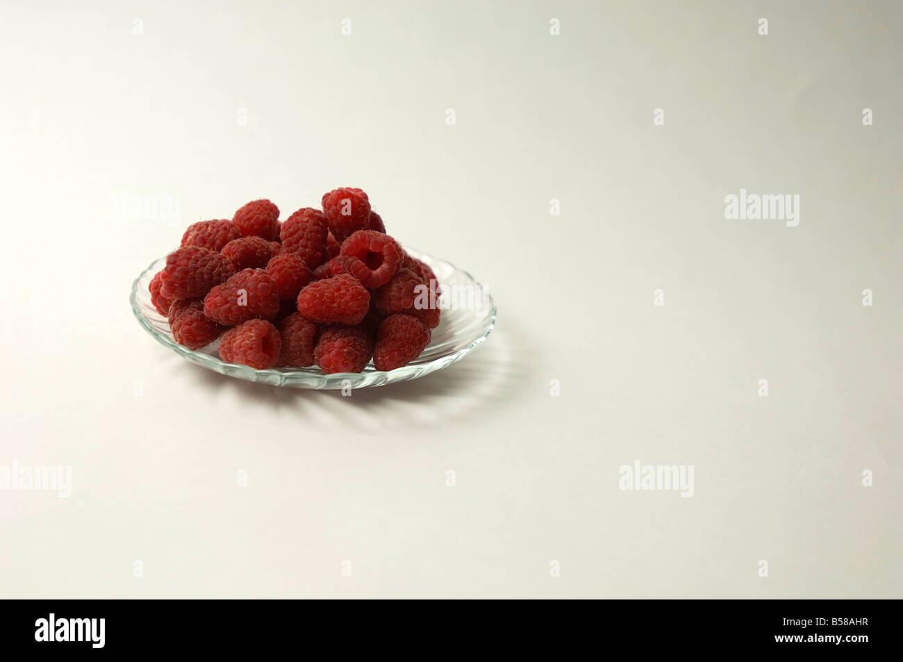 Dish of fresh red raspberries on a white cut out style background Stock ...