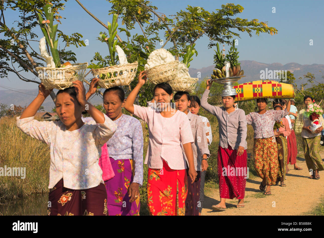 People walking to Monastery carrying offerings on their heads, Novice ...