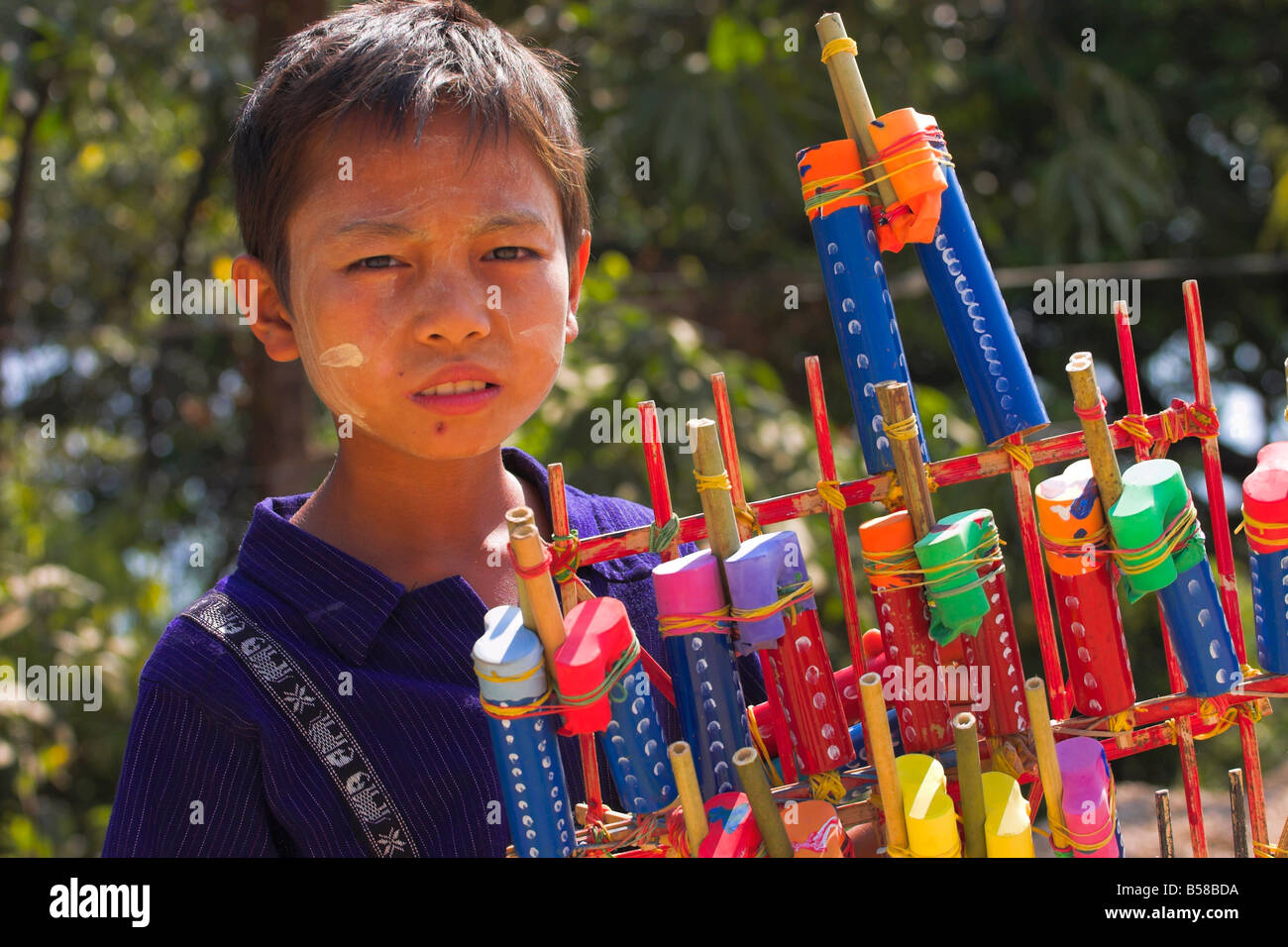 Boy selling musical instruments at Kyaikhtiyo Paya (Golden Rock Pagoda ...