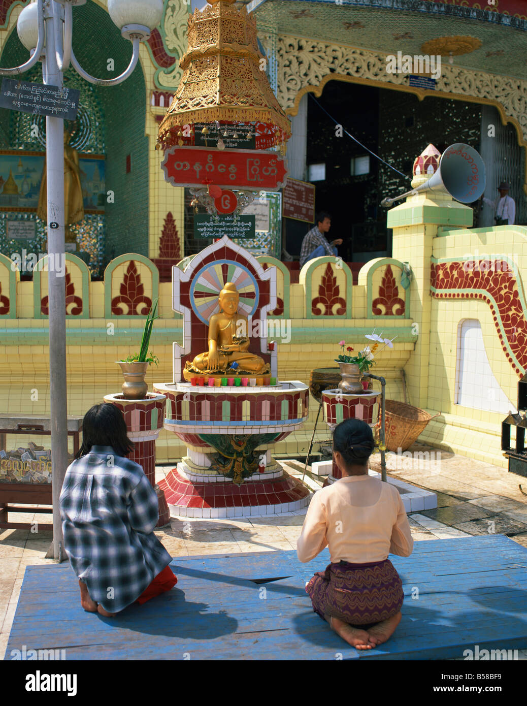 Two people praying at a pagoda Yangon Rangoon Myanmar Burma Asia R ...