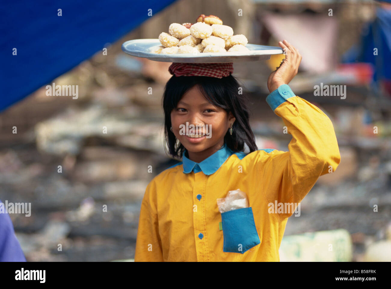 Young girl carrying plate on head Phnom Penh Cambodia Asia G Hellier ...