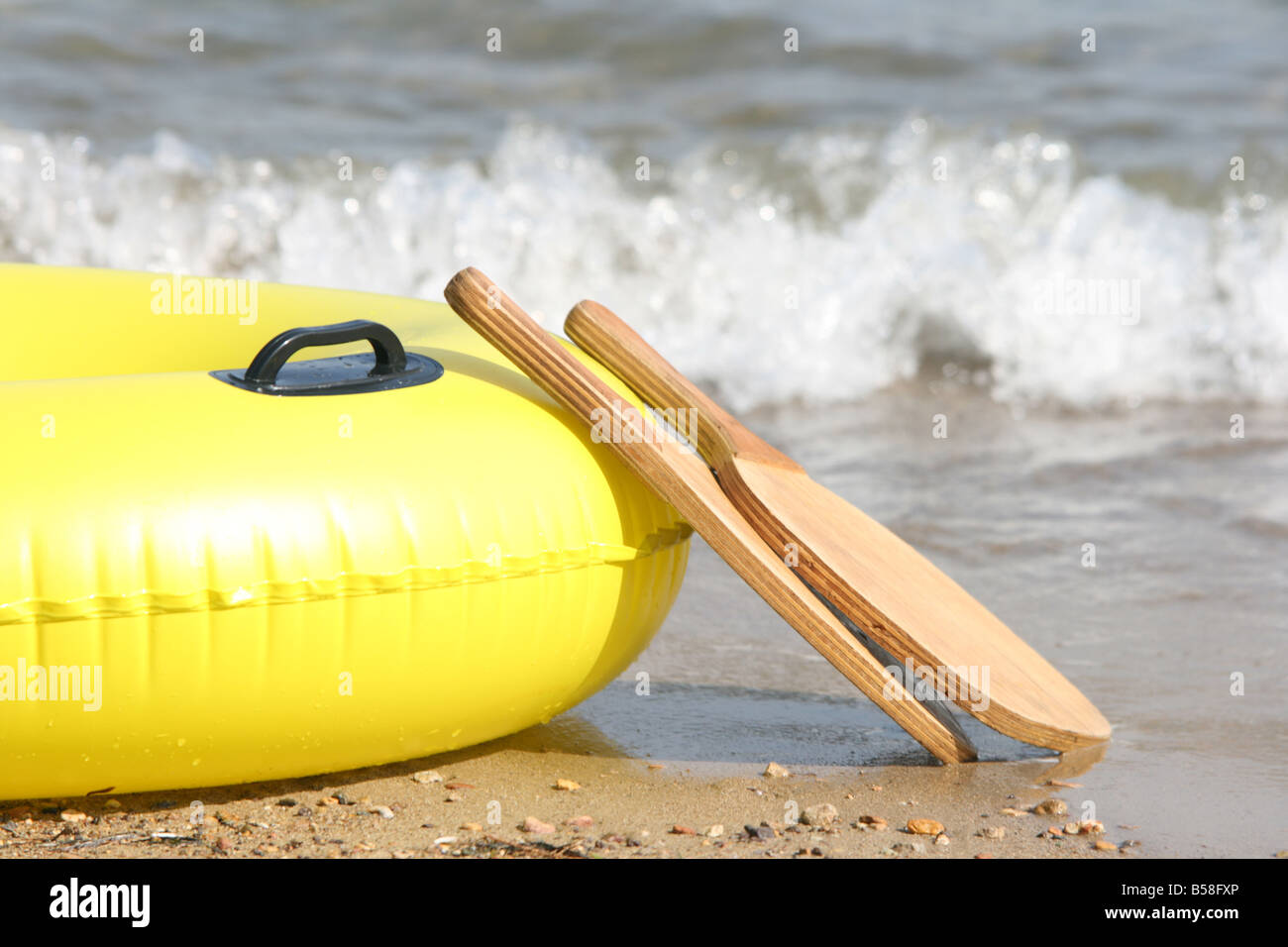 detail yellow inflatable by the sea and wooden beach tennis rackets ...