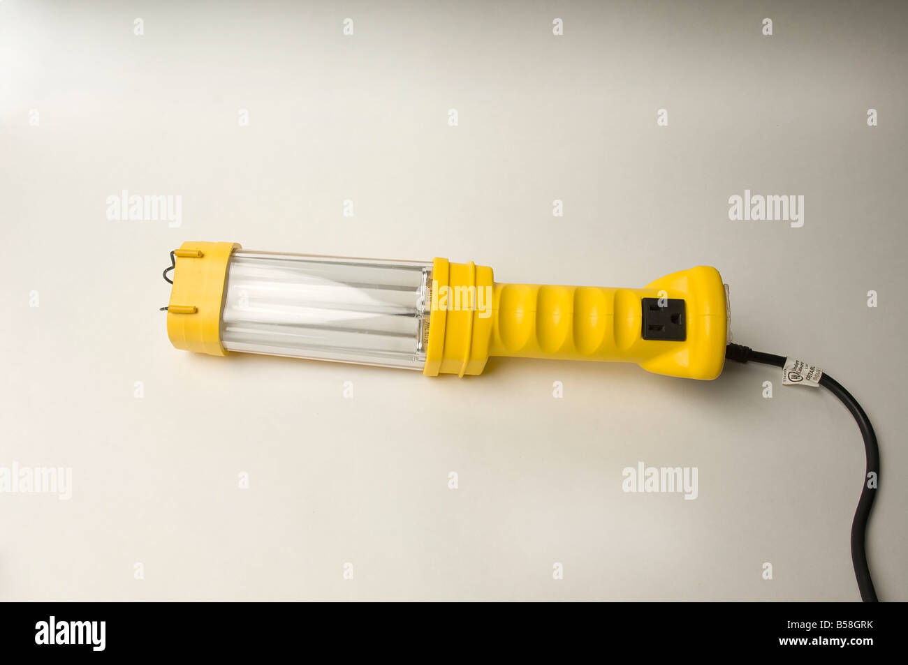 Fluorescent shop light or work light with a yellow plastic housing on a ...