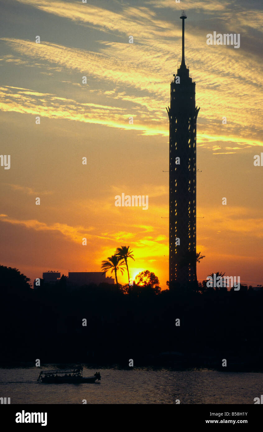 View at sunset of the Tower of Cairo and palm trees with small boat on ...