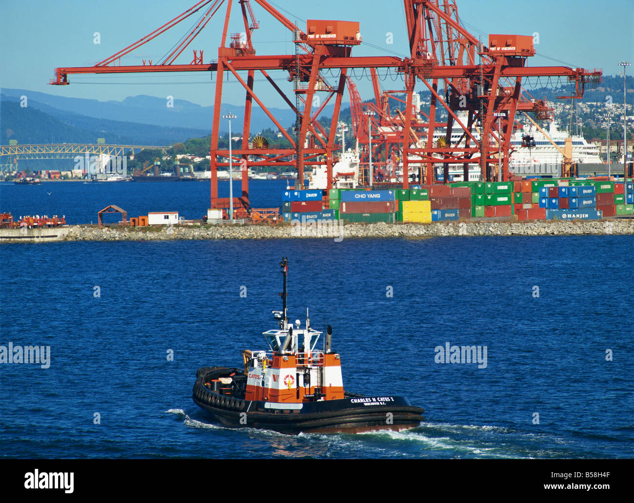 Harbour tug with containers and cranes in the background, in Vancouver ...