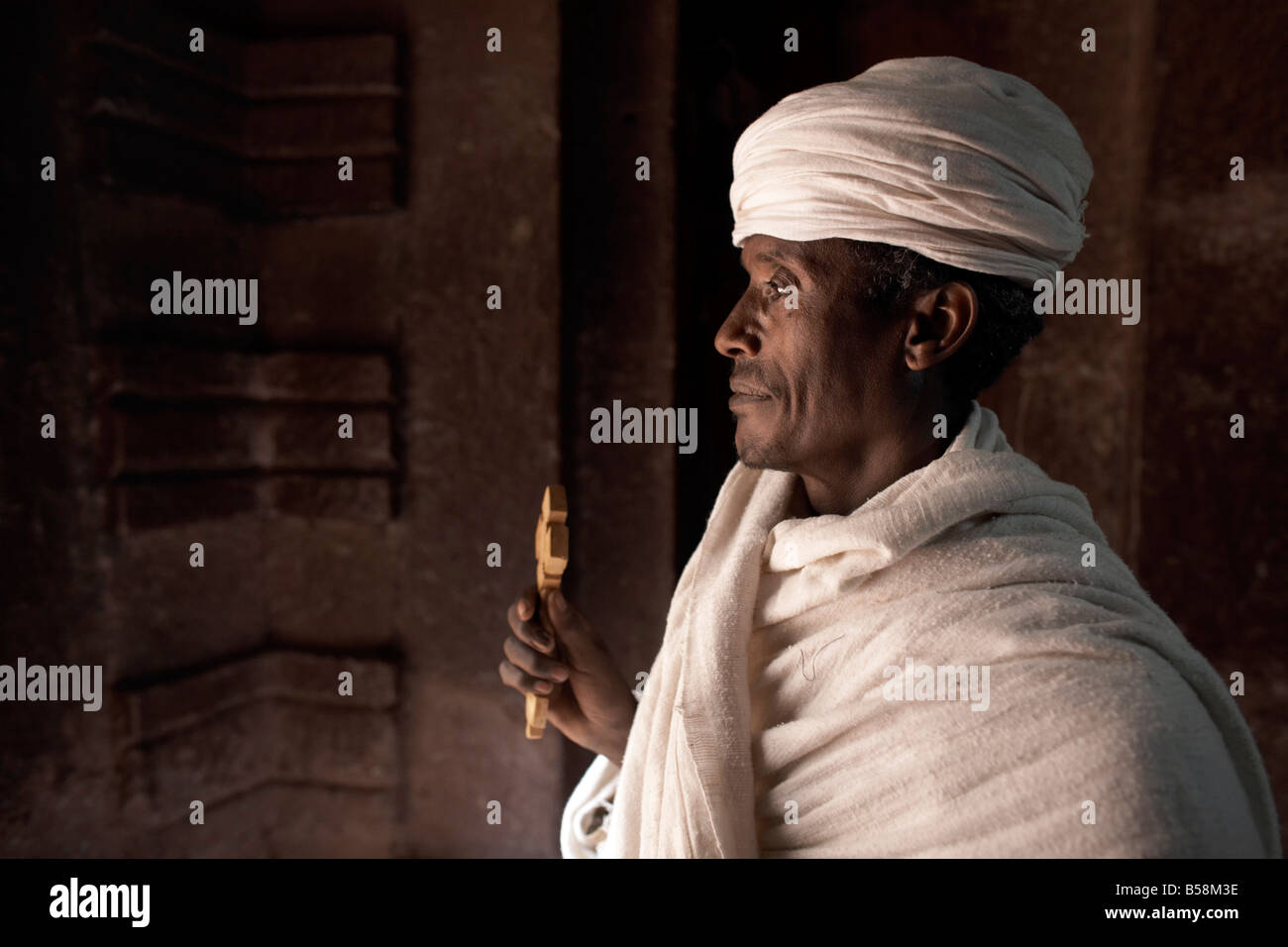 A priest stands at the entrance to the rock-hewn church of Bet Amanuel ...
