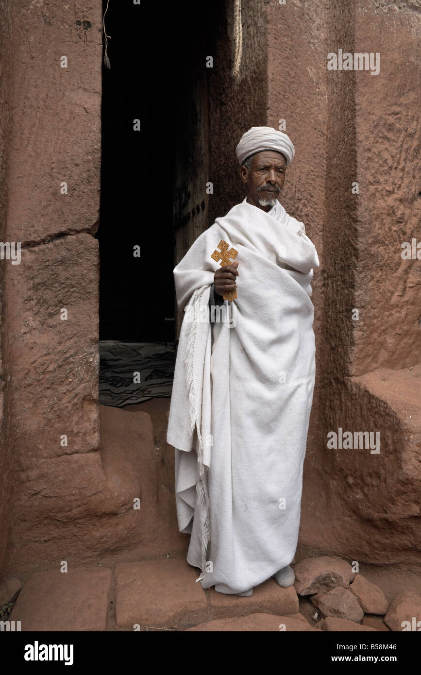 A priest stands at the entrance to the rock-hewn church of Bet Gabriel ...