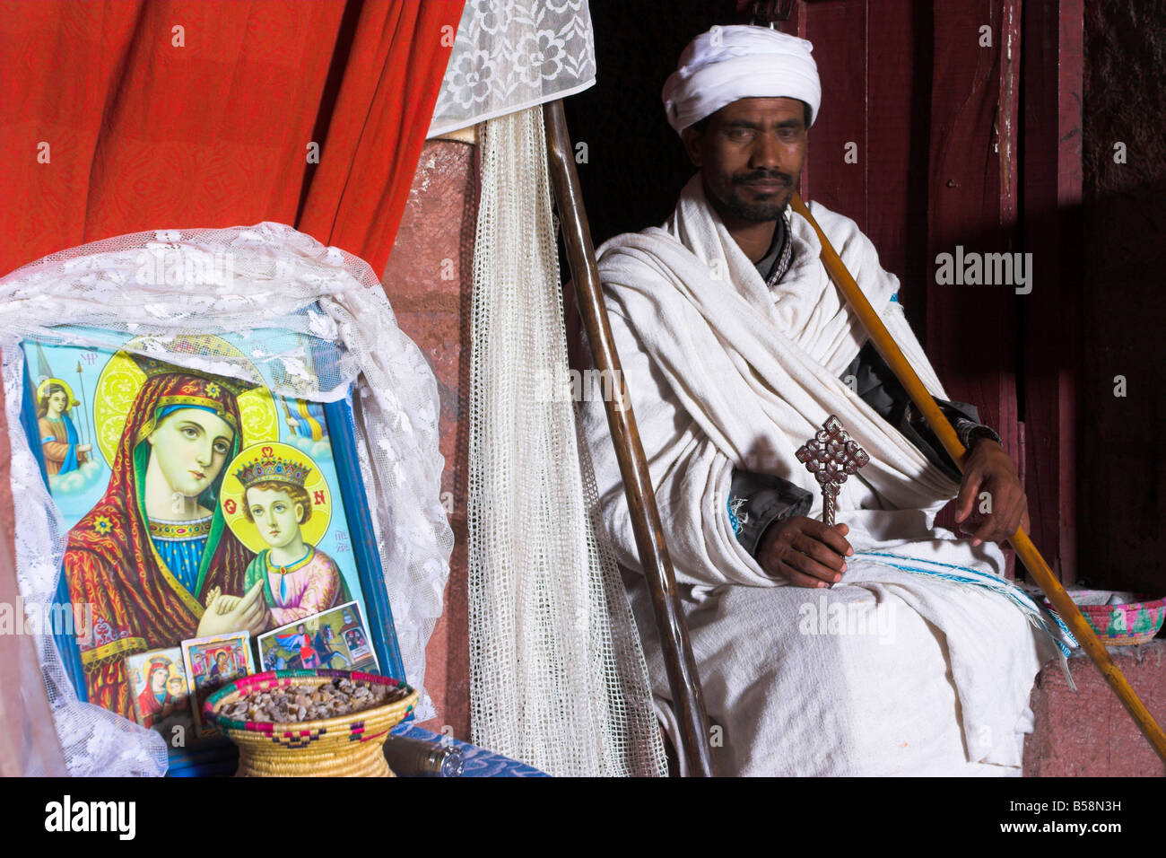 Priest holding cross inside Bet Gabriel Rufael Lalibela Ethiopia Africa ...
