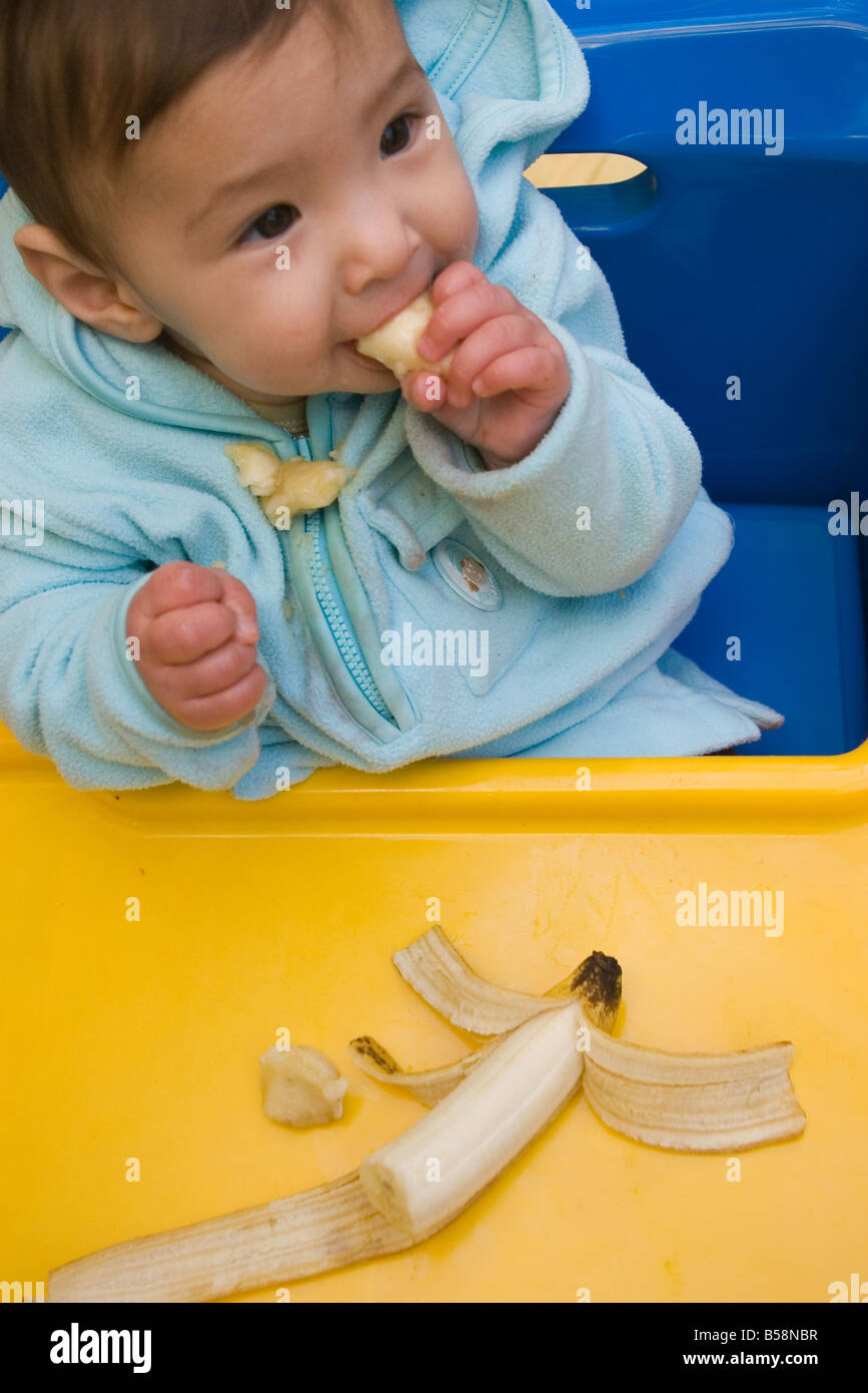 eating weaning a banana fruit in a high chair healthy snack for a baby ...