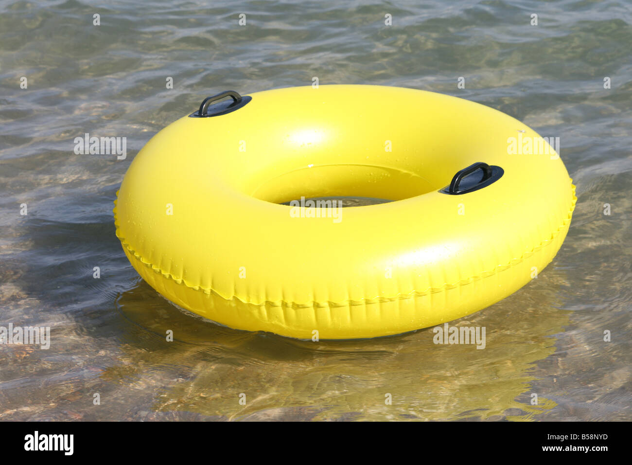 large yellow Inflatable Swimming Ring floating in the sea Stock Photo ...