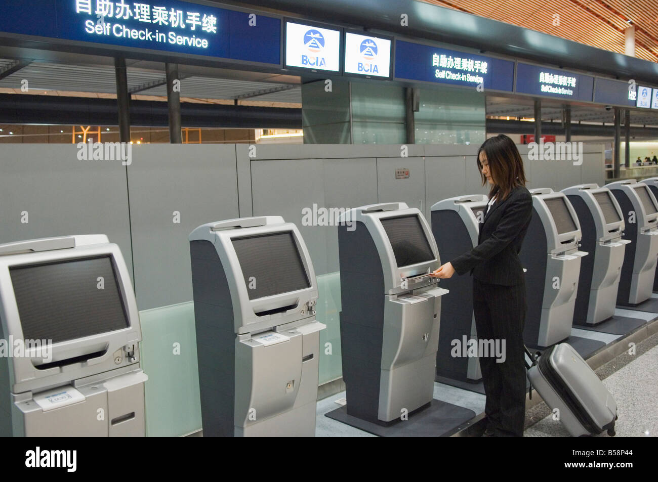 A Chinese business woman using the self service check in machines at ...