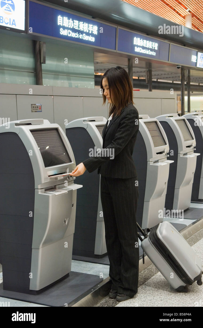 A Chinese business woman using the self service check in machines at ...